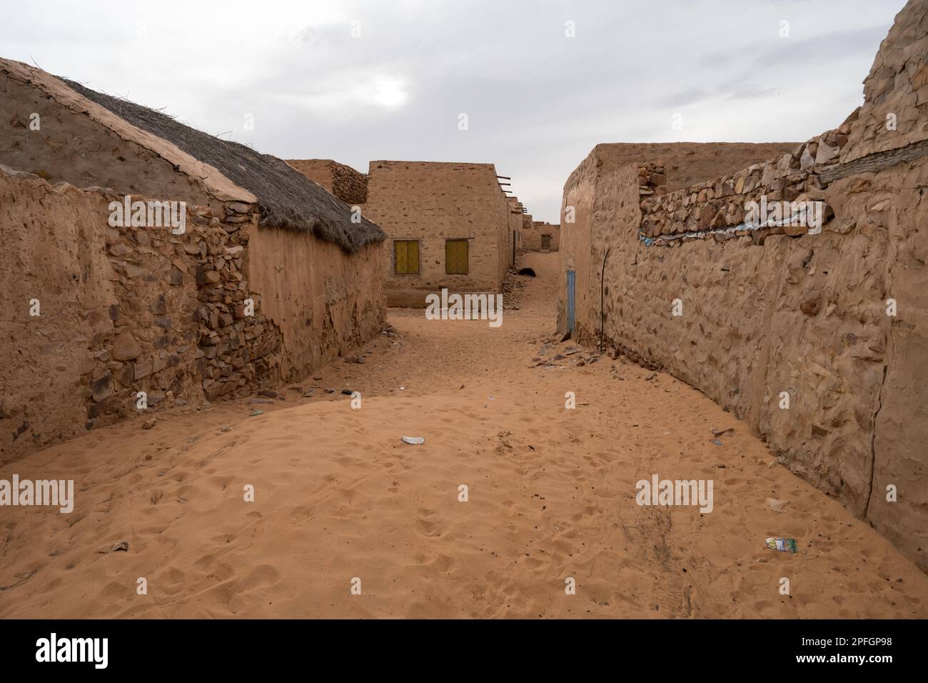 A narrow street in the ancient city of Chinguetti, Mauritania, lined ...