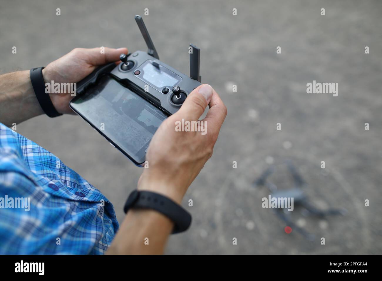 Man holds remote control in hands and controls drone Stock Photo - Alamy