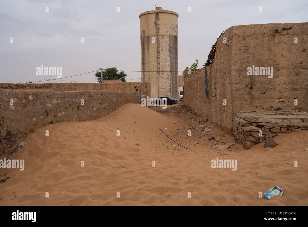 A narrow street in the ancient city of Chinguetti, Mauritania, lined ...