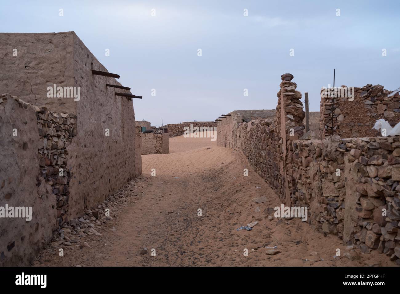 A narrow street in the ancient city of Chinguetti, Mauritania, lined ...