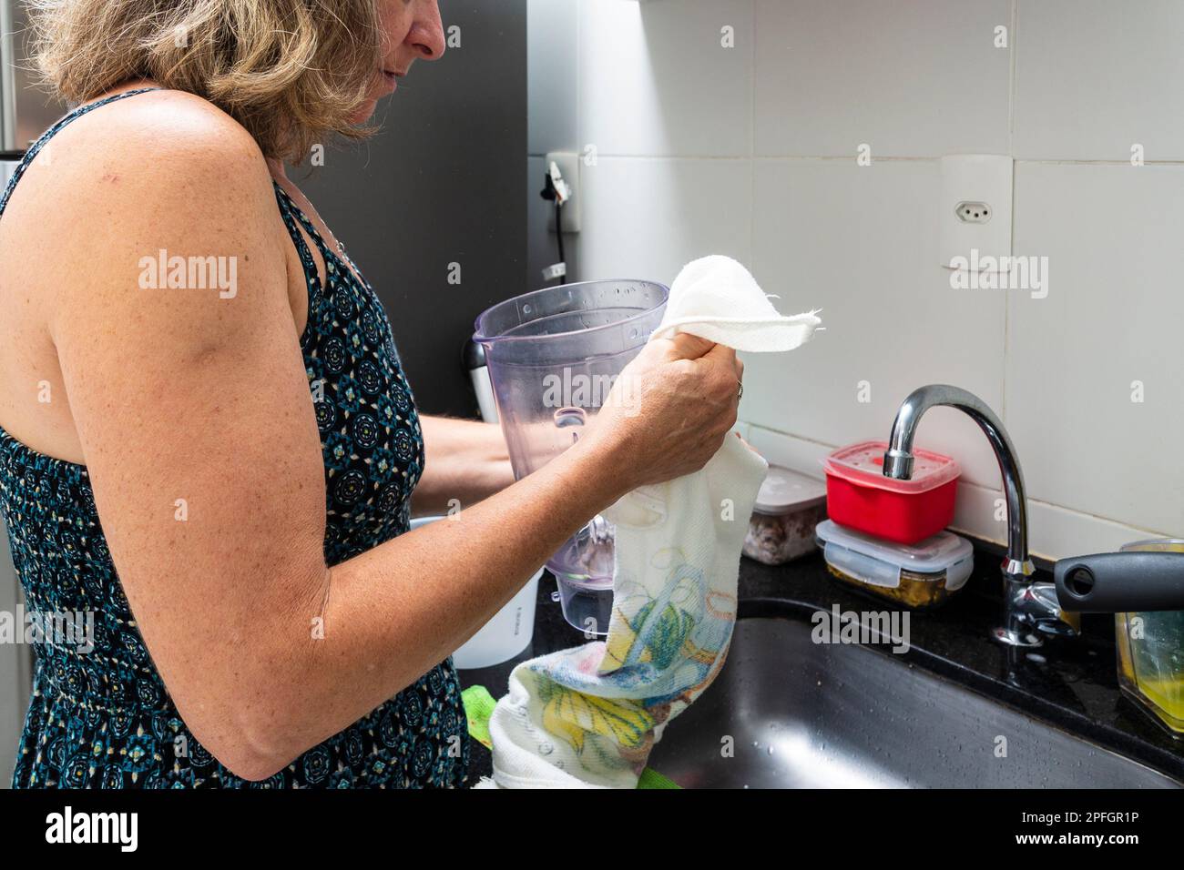 Young woman washing pan and utensils in the kitchen. Hygiene in the ...