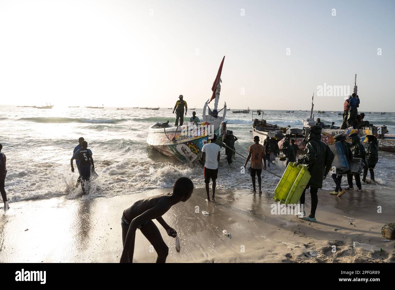 African fishermen unloading the day's catch of fish. Port de Peche ...