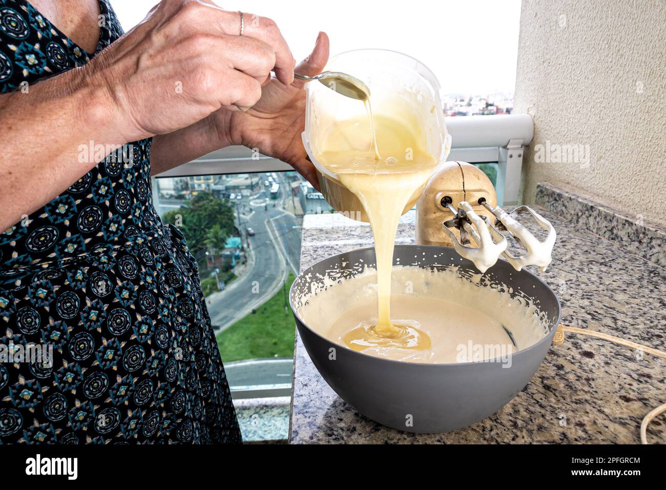 Woman cook putting ingredient into cheesecake preparation container ...