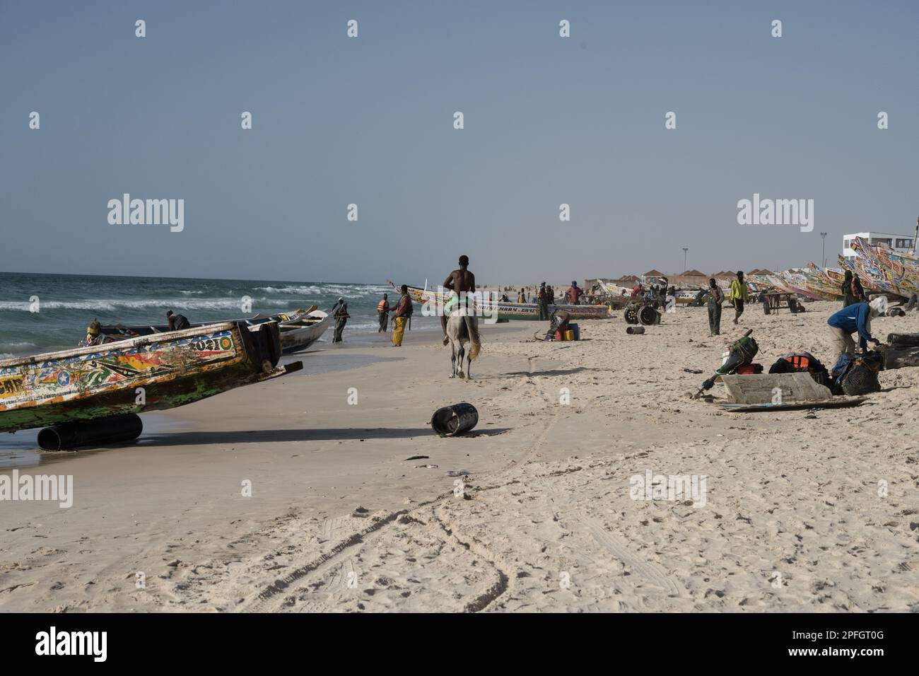African fishermen unloading the day's catch of fish. Port de Peche ...