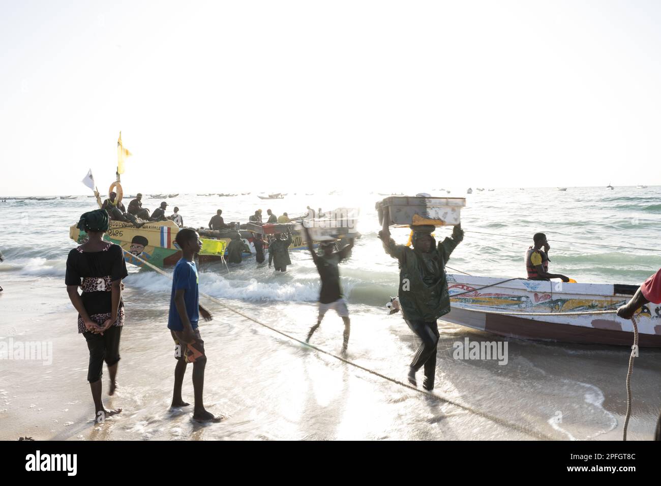 African fishermen unloading the day's catch of fish. Port de Peche ...
