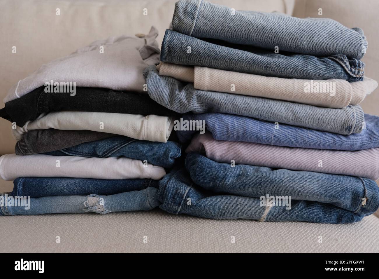 Denim pants, different colours of folded and stacked denim pants on a ...