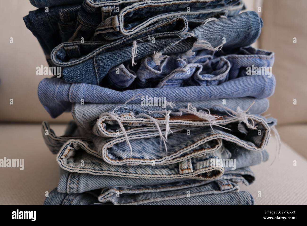 Folded denim jeans pants, different shades of denim jeans in a row on a ...