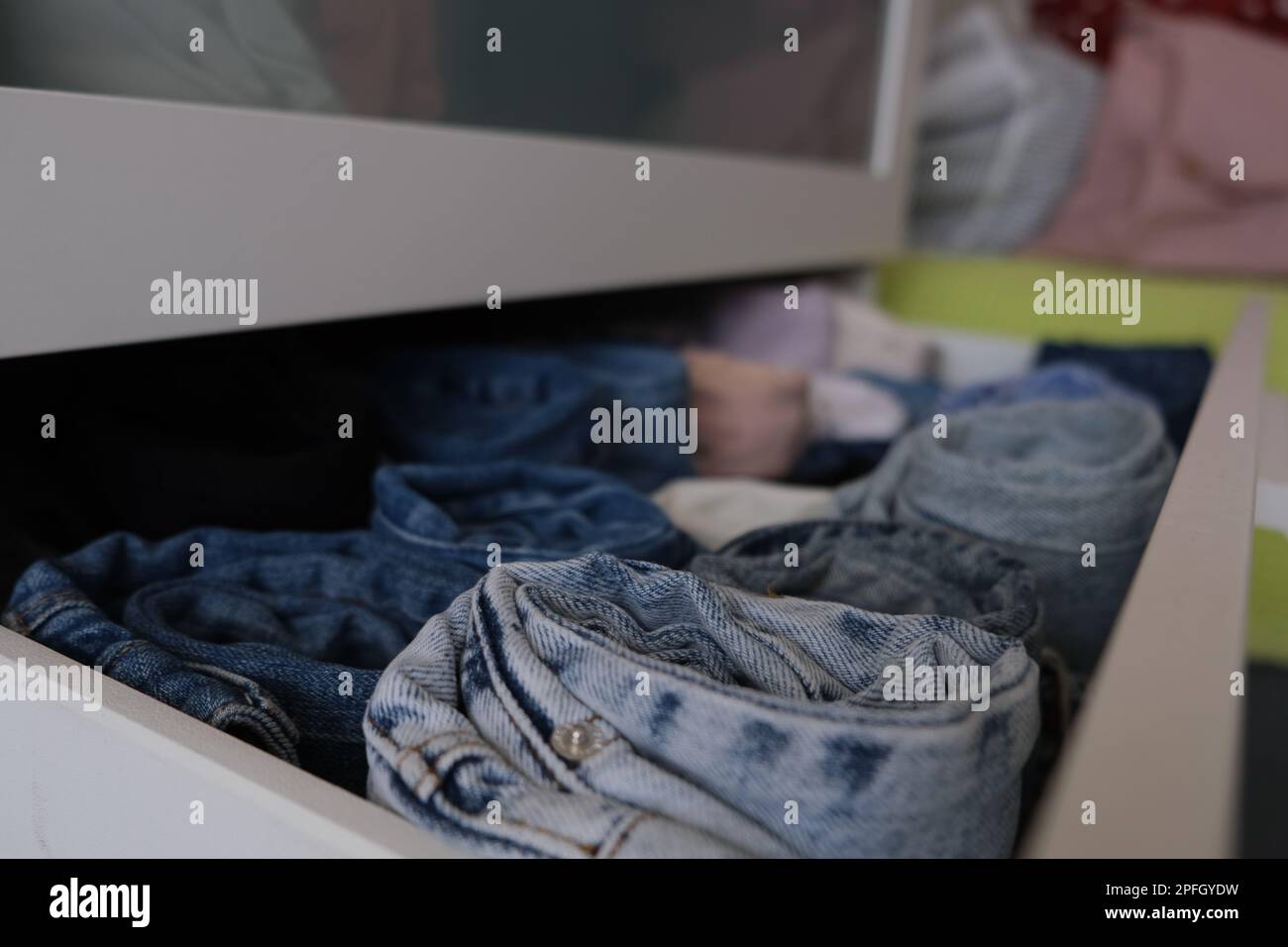 Drawer full of denim clothes, open drawer with folded denim jeans ...