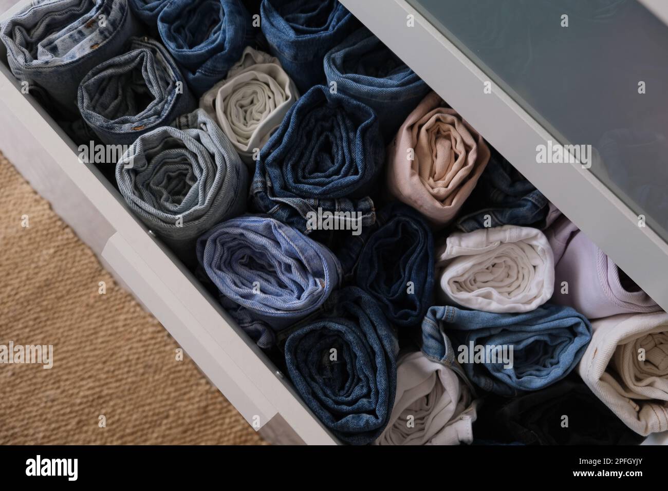 Drawer full of denim jeans, open drawer with folded denim jeans indoors ...