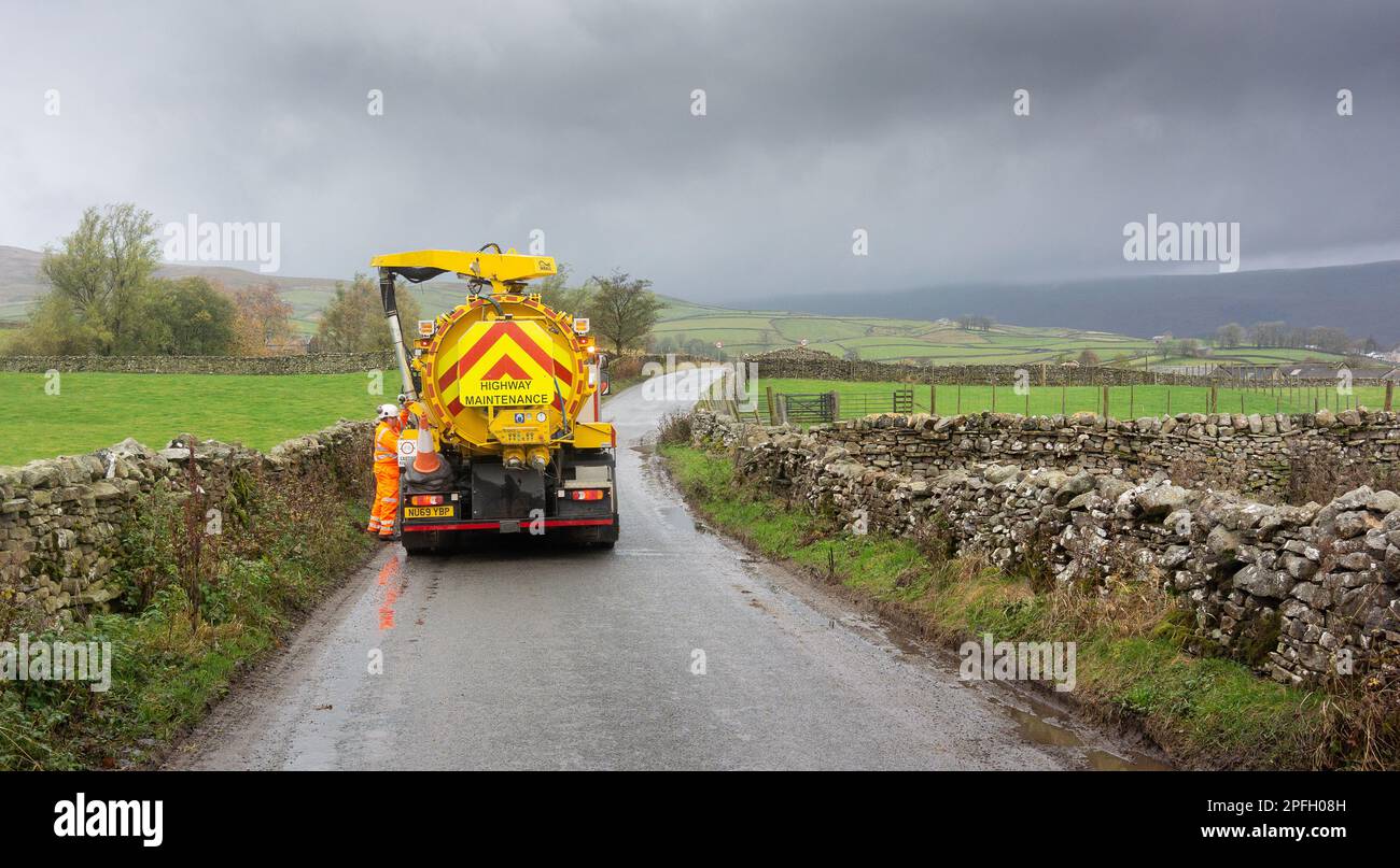 Cleaning out drains on a rural road to help prevent flooding on the ...