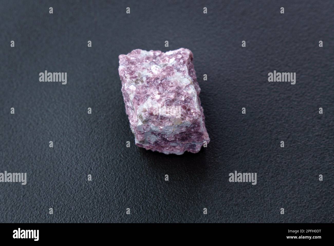Lepidolite stone on a black background, being a secondary source of ...