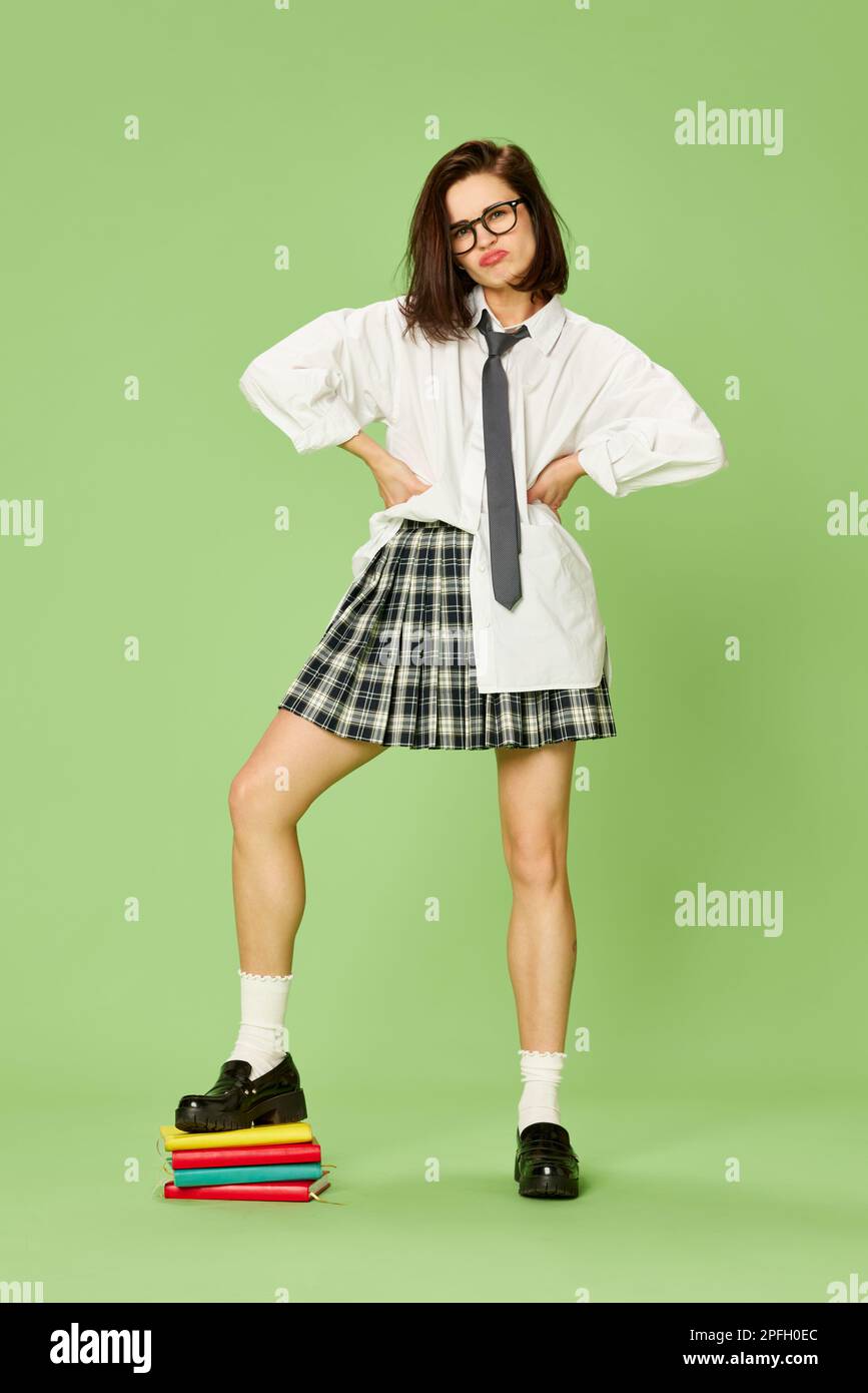 Exam session. Young beautiful woman, student in checkered skirt and ...