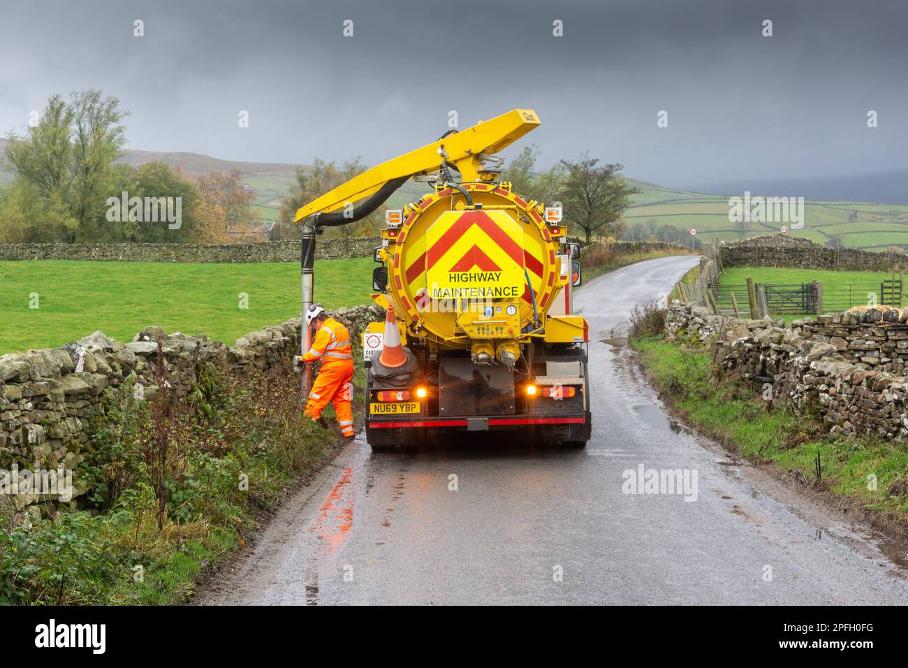Cleaning out drains on a rural road to help prevent flooding on the ...