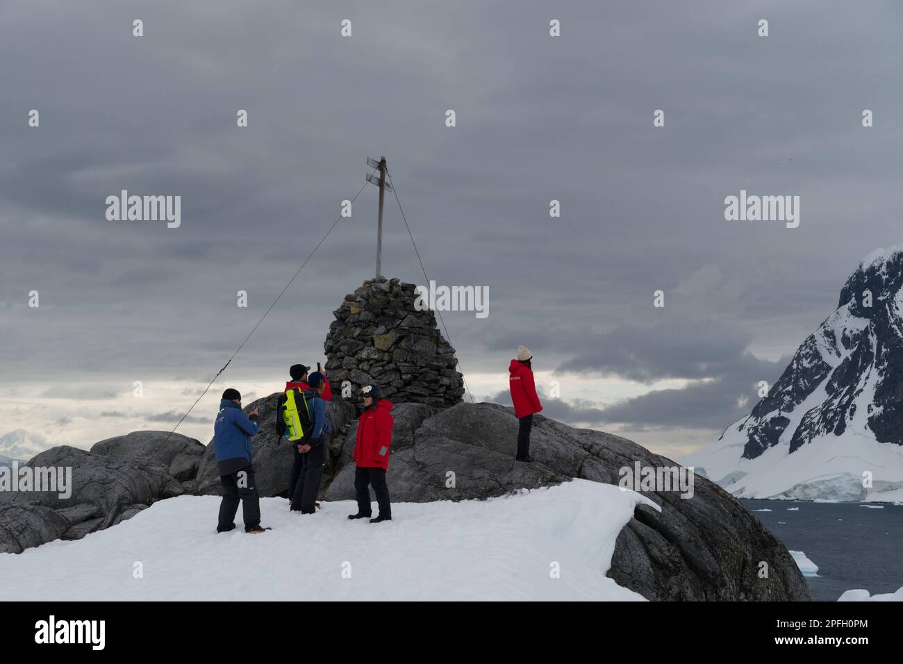 tourists visiting the Jean-Baptiste Charcot cairn on Booth Island ...