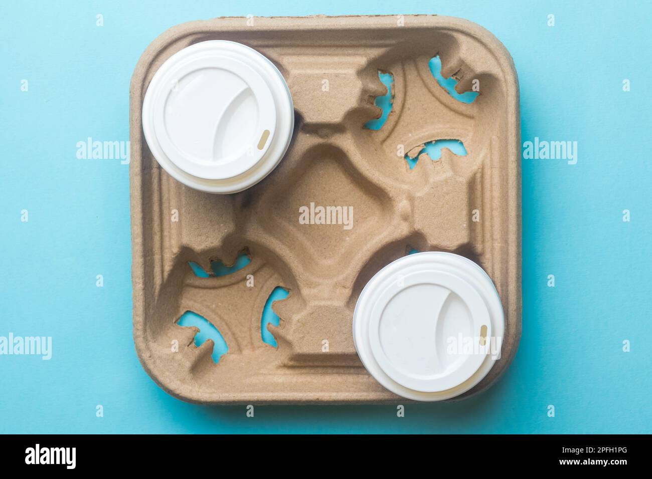 A cardboard tray for carrying paper coffee cups with two cups and lids ...