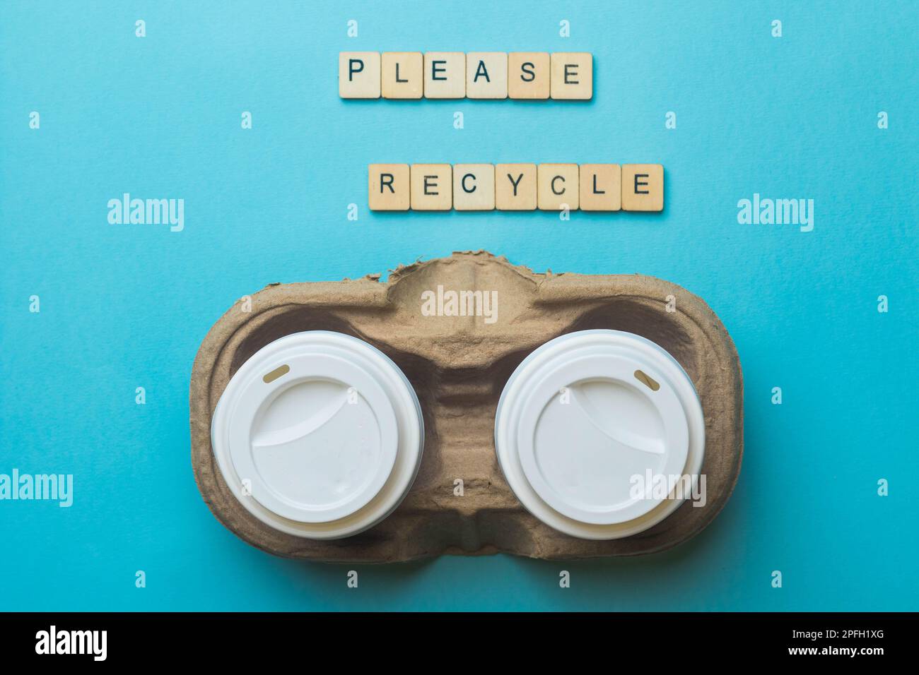 A carboard tray with 2 Coffee Cups and a sign reading please recycle ...