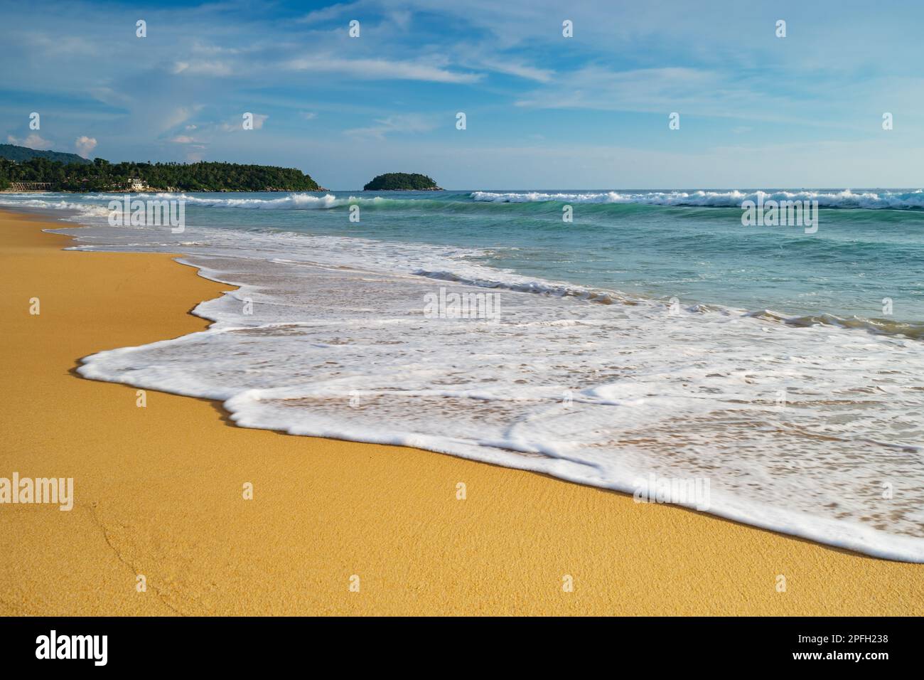 Tropical sandy beach with waves crashing on sandy shore and blue sky background, Image for ...