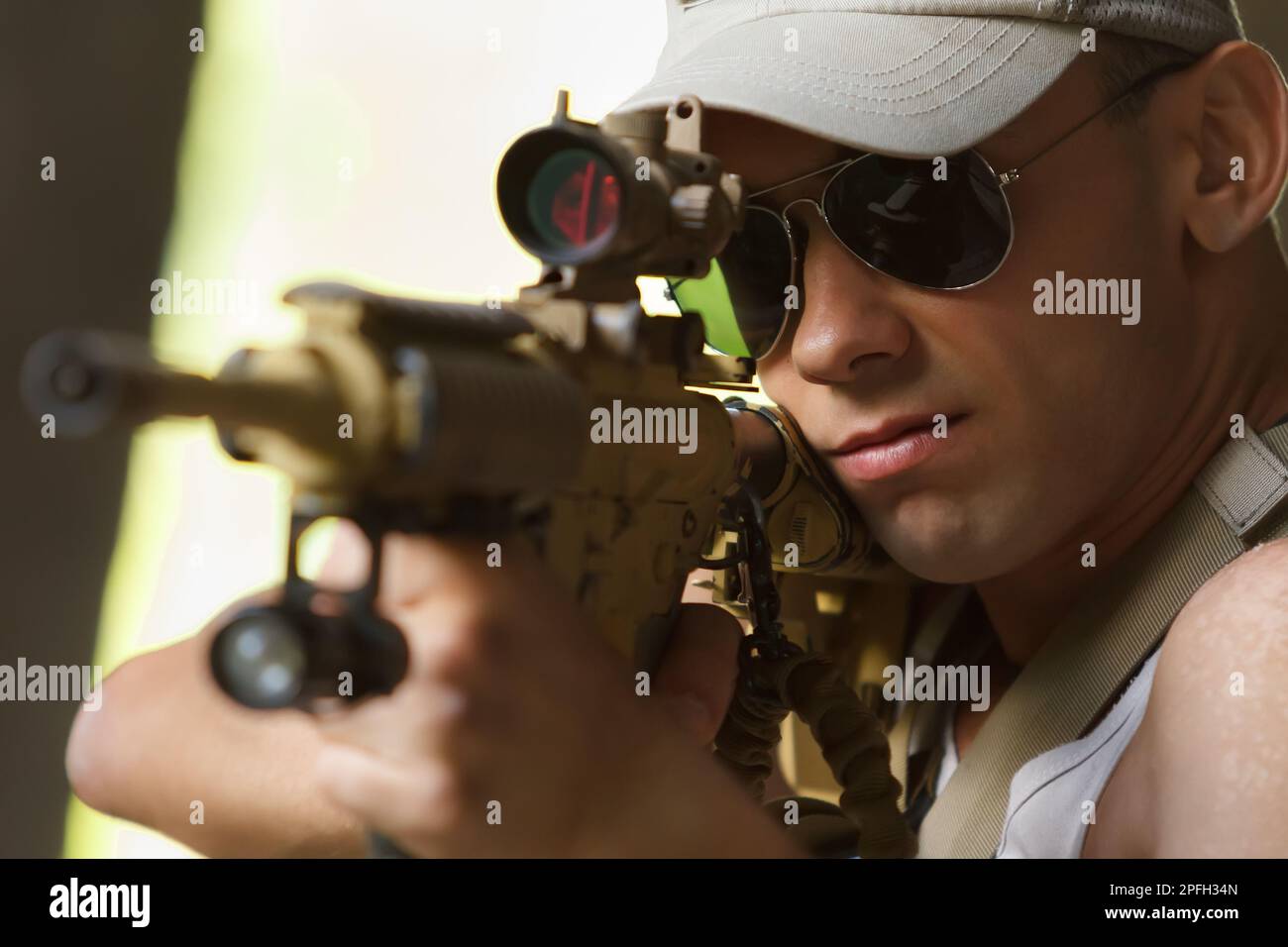 Portrait of cool young Ukrainian soldier aiming the target with optical ...