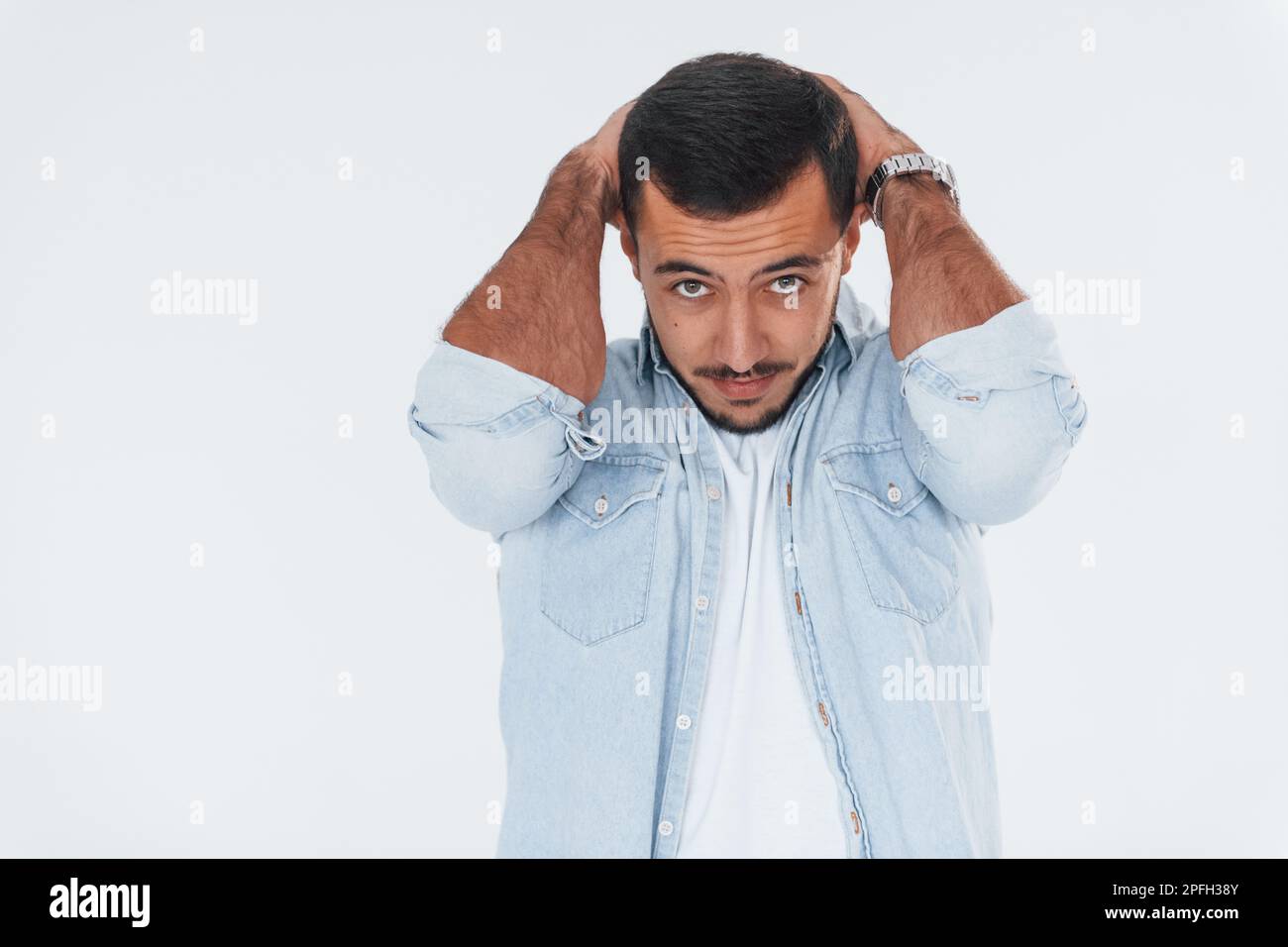 Stressful young man standing indoors against white background Stock ...