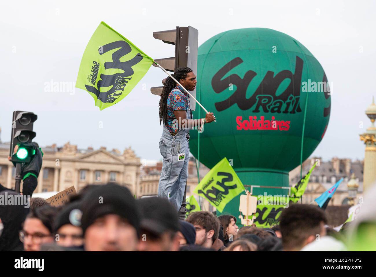 Paris, France 16th Mar, 2023. A protester seen hanging from a traffic ...