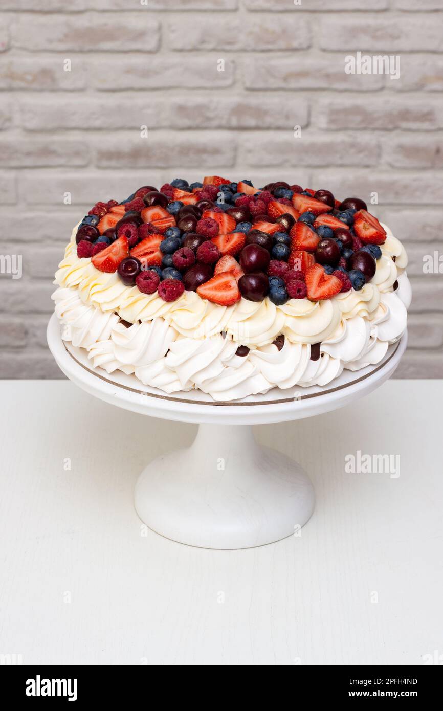 Meringue Pavlova cake with whipped cream and fresh berries ...
