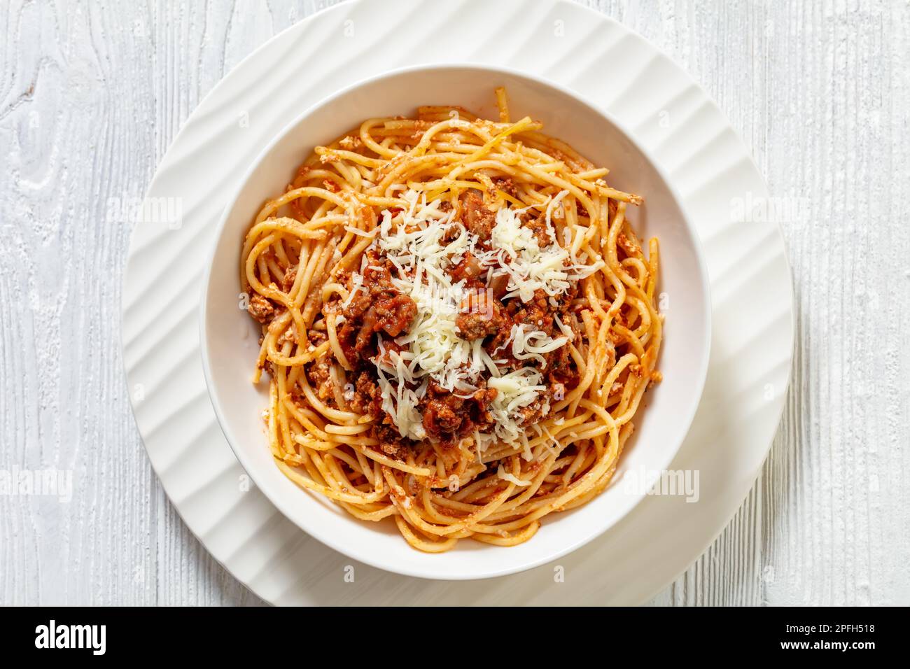 spaghetti al ragu alla Bolognese topped with shredded cheese in white ...