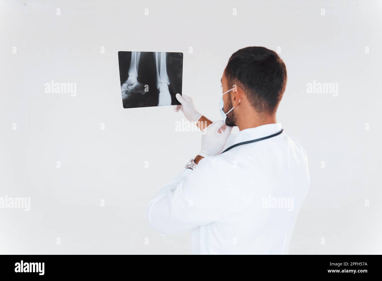 Medic with x-ray. Young handsome man standing indoors against white ...