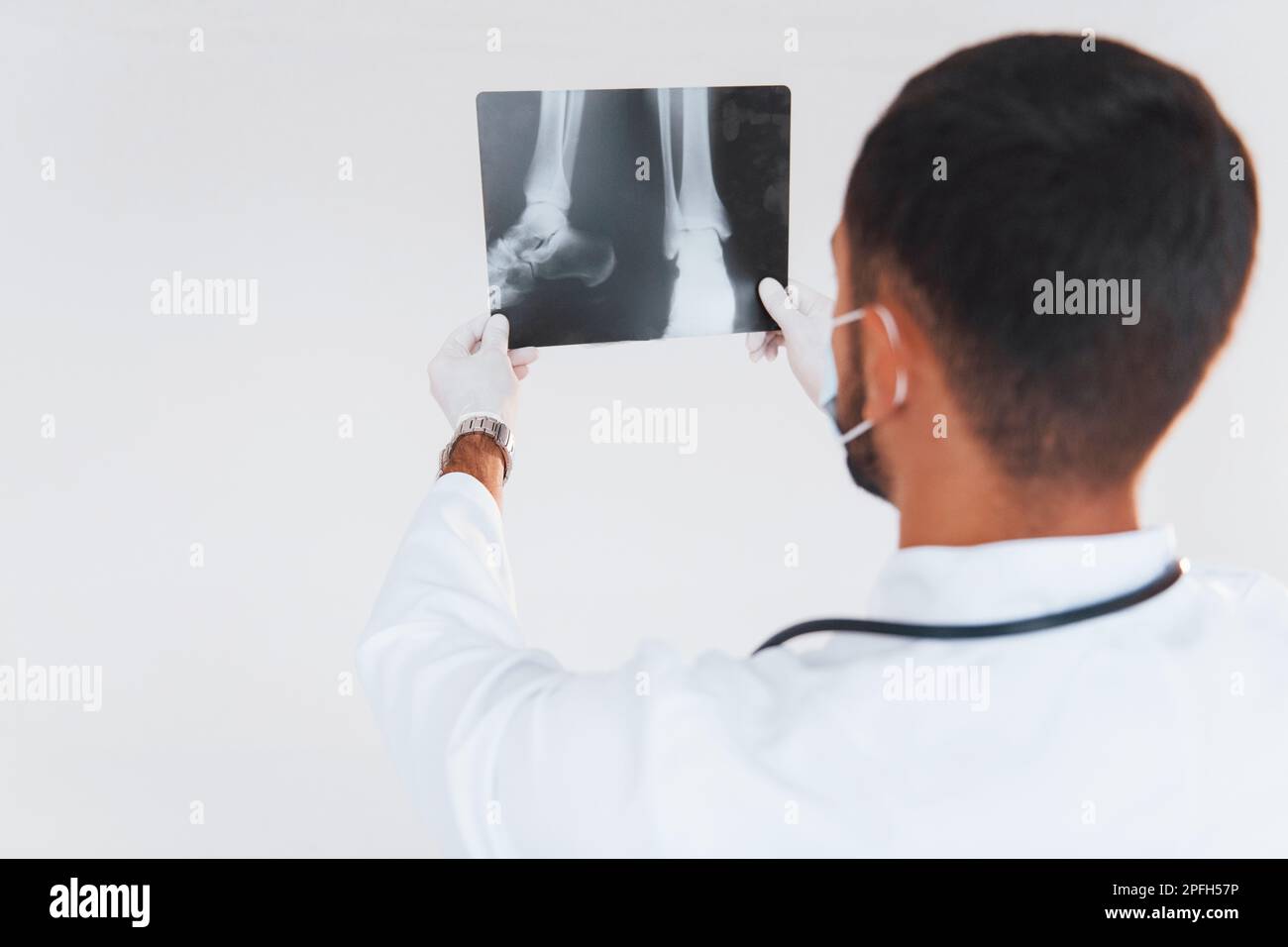 Medic with x-ray. Young handsome man standing indoors against white ...