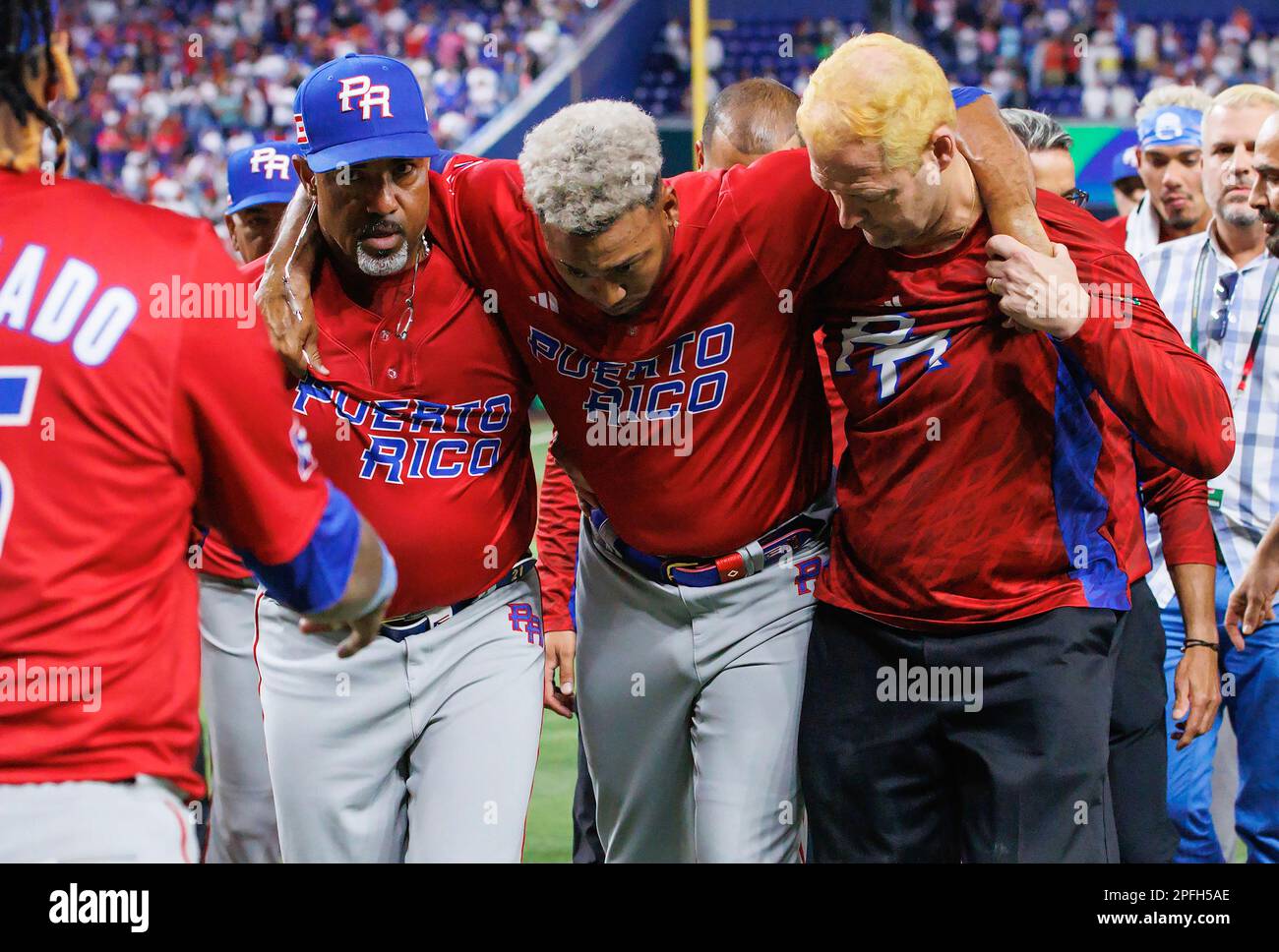 Puerto Rico pitcher Edwin Diaz (39) is being helped by team pitching ...