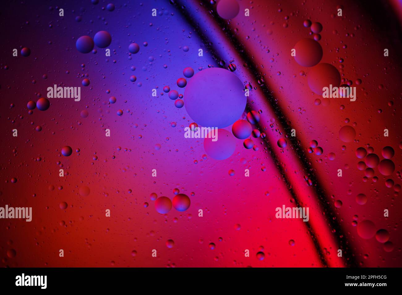 Oil drop in the water. Colour background. Glass jar Stock Photo - Alamy