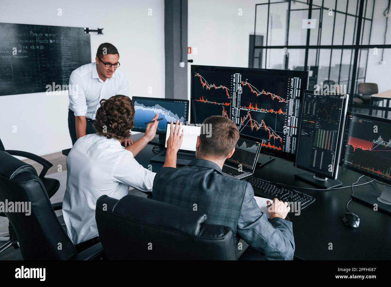 Conception of teamwork. Team of stockbrokers works in modern office ...