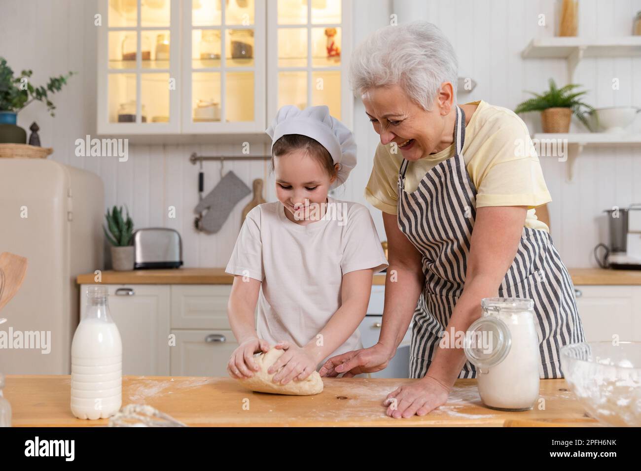 Happy family in kitchen. Grandmother and granddaughter child cook in ...