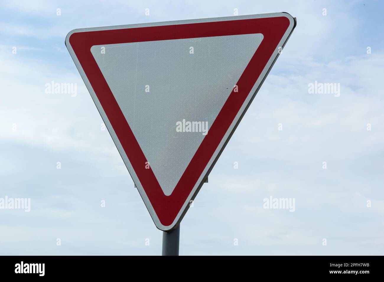 Road sign against the sky. White triangle with red border. Signal, Give ...