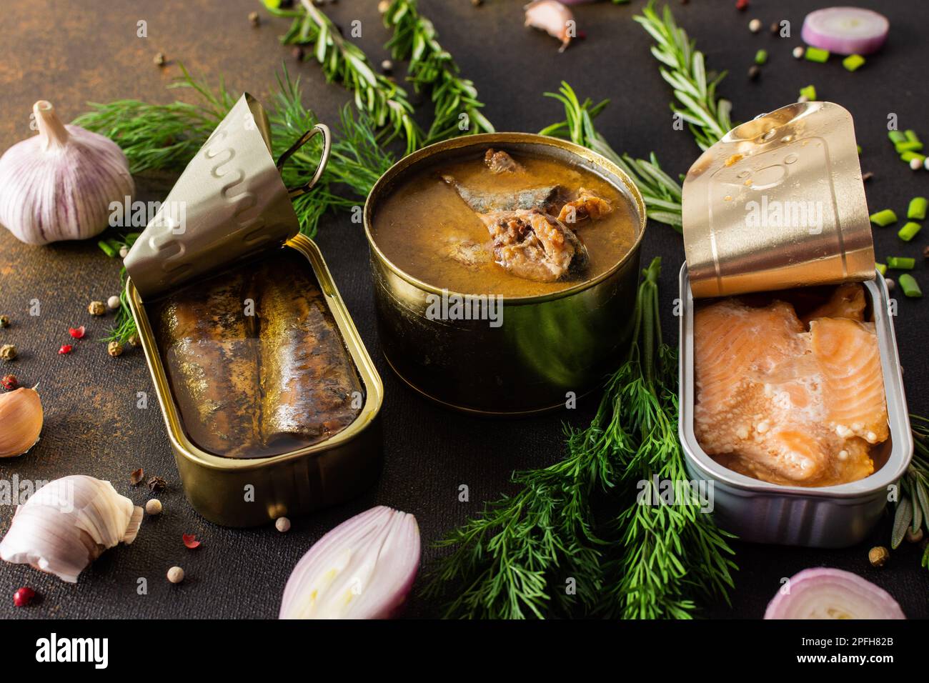 Different open tin cans with canned fish among spices and herbs, canned ...