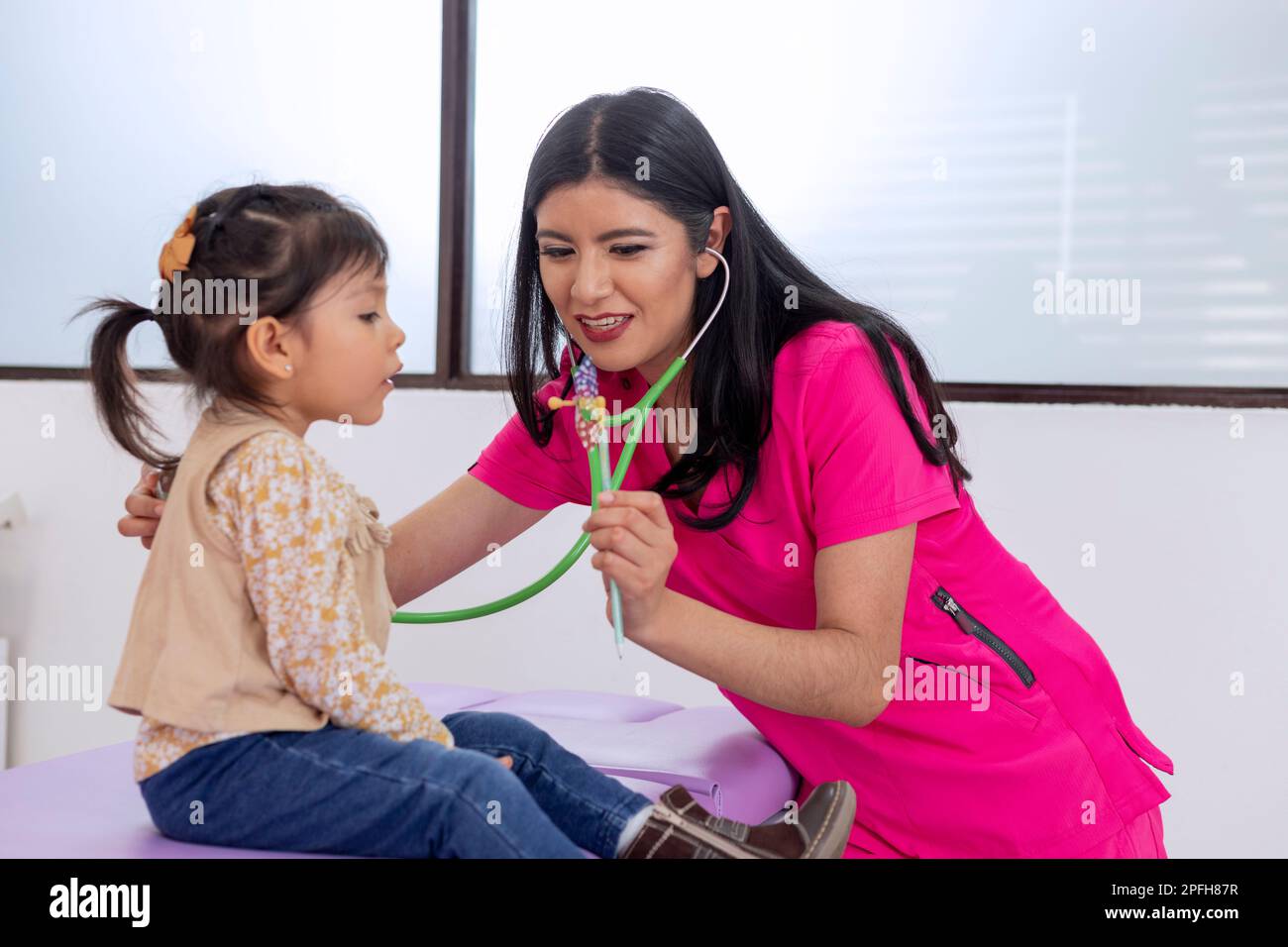 Pediatrician doing a breathing test to a little girl in her medical ...