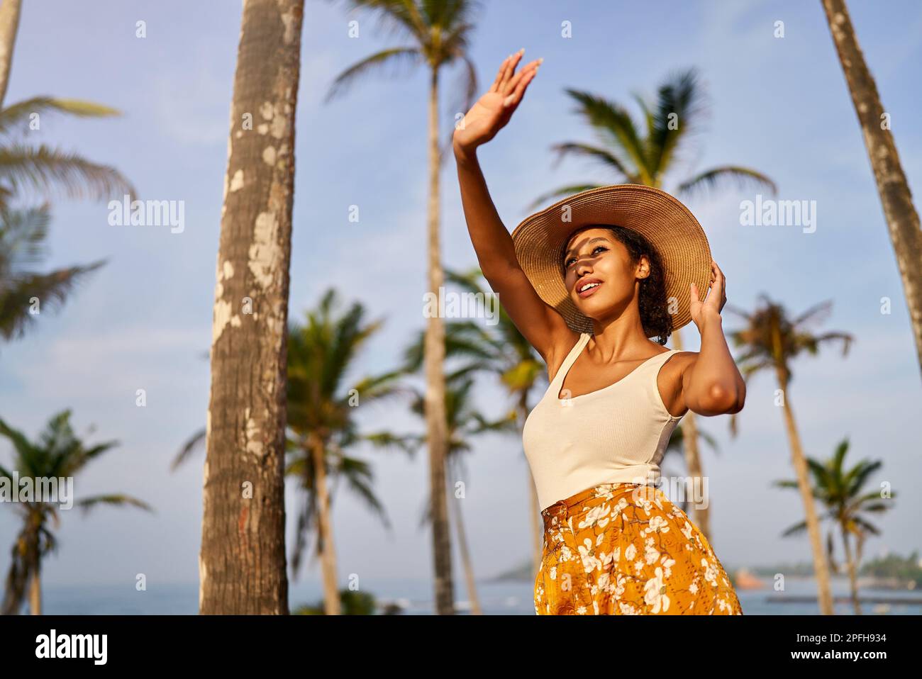 Young african female model posing in colorful clothes at tropical ...