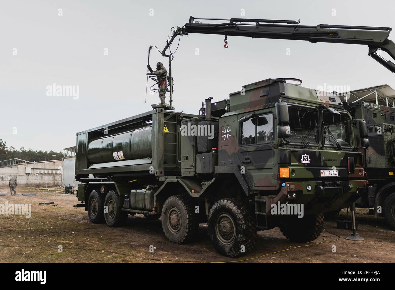 Two NBC defense soldiers in protective gear, pictured decontaminating a ...