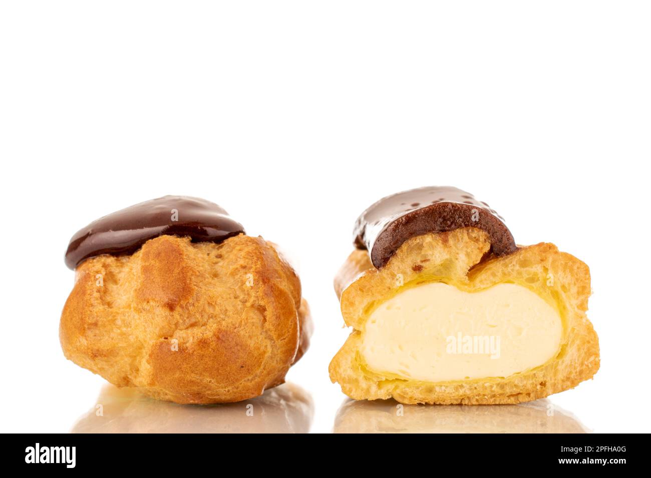 One sweet chocolate eclair cut in half, close-up, isolated on white ...