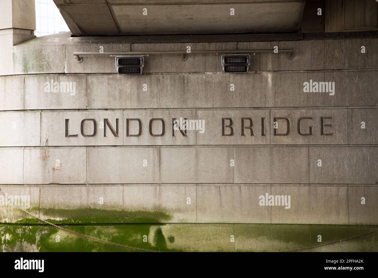 Name sign on London Bridge written into the pier and seen from boat ...