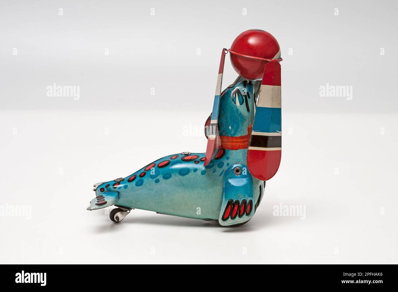 An old wind-up child's toy, a blue metal seal with wheels, and a ball ...