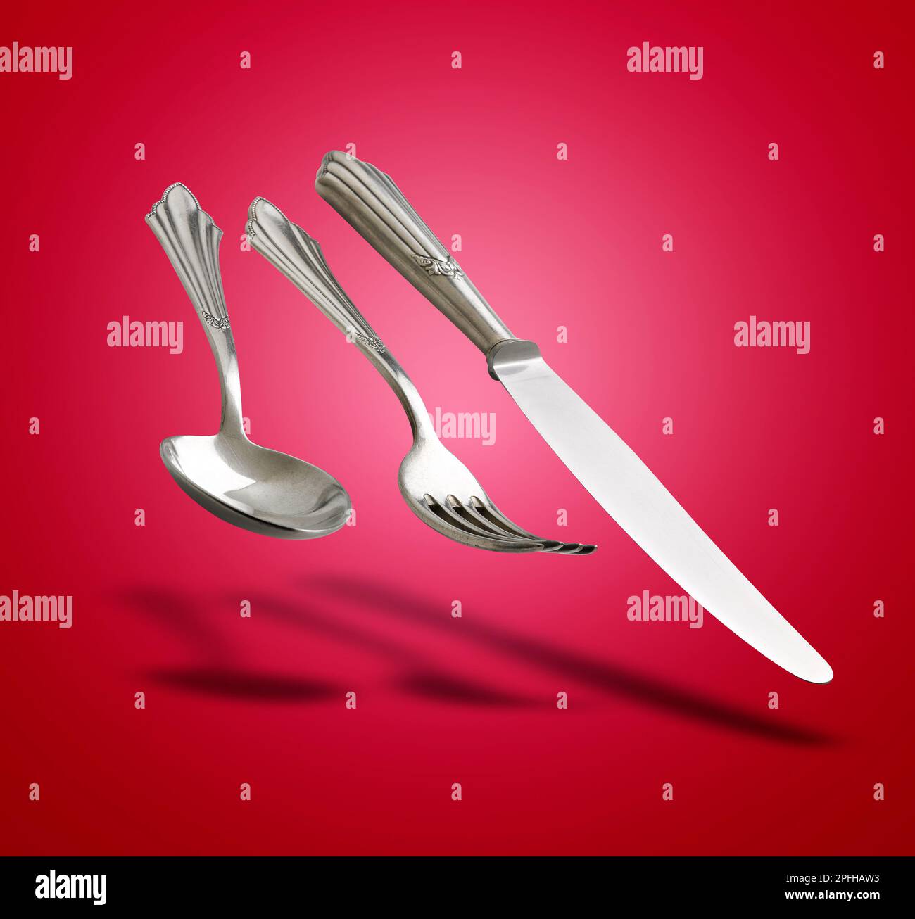 Floating Old Silverware Set with shadows on red gradient background ...