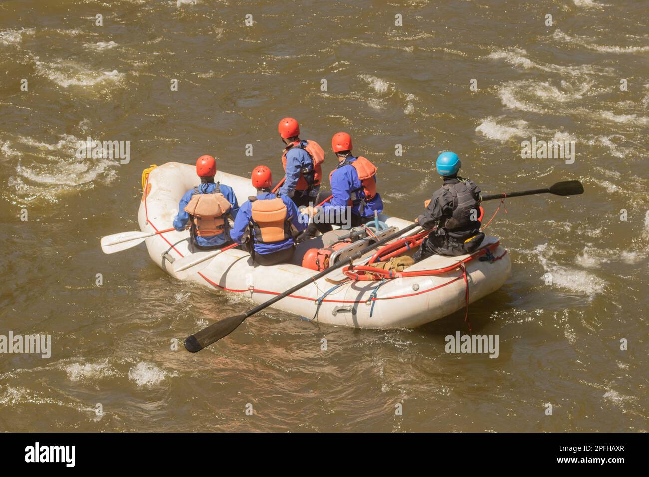 Men on a raft taking a whitewater rafting trip down a river in the San ...