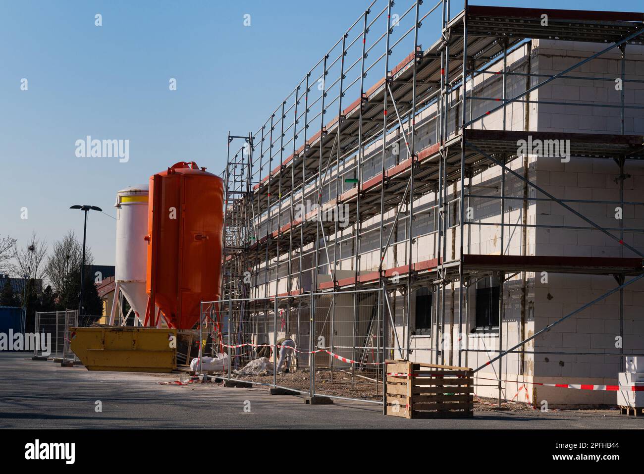 Building under construction in scaffolding. Two cylindrical elevators ...