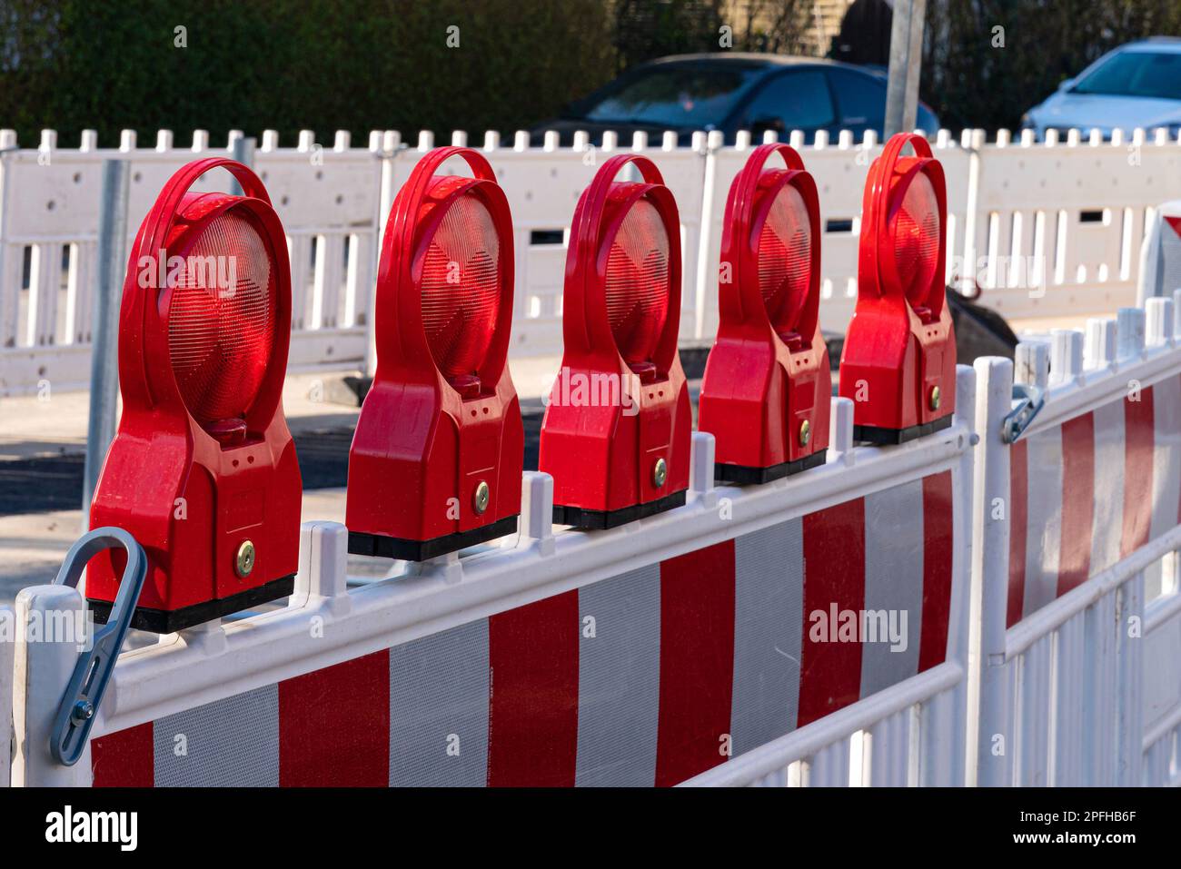 Construction plastic barrier at a road with red reflecting lamps as ...