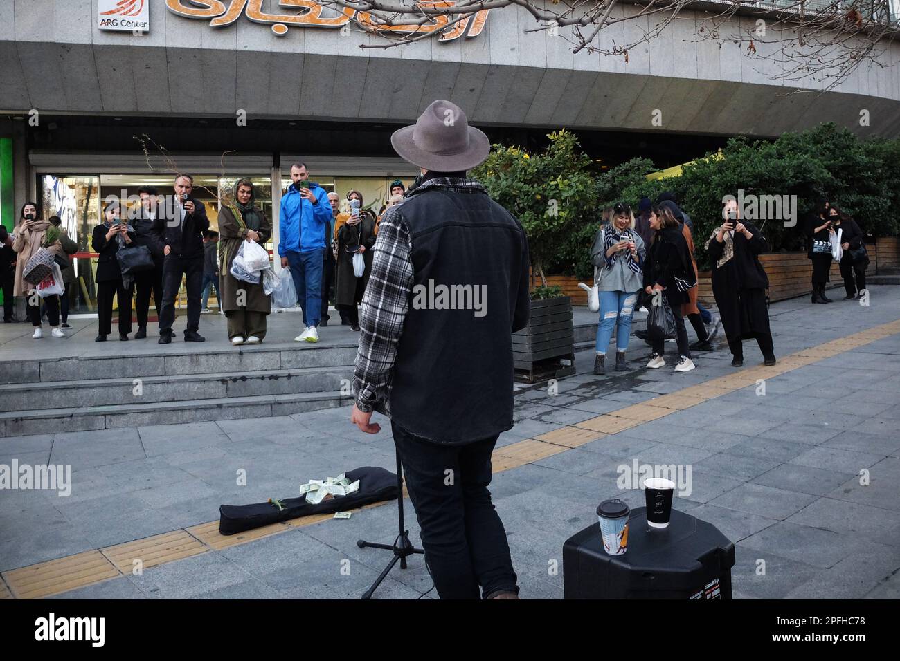 Tehran, Tehran, Iran. 16th Mar, 2023. People look at a street singer in ...