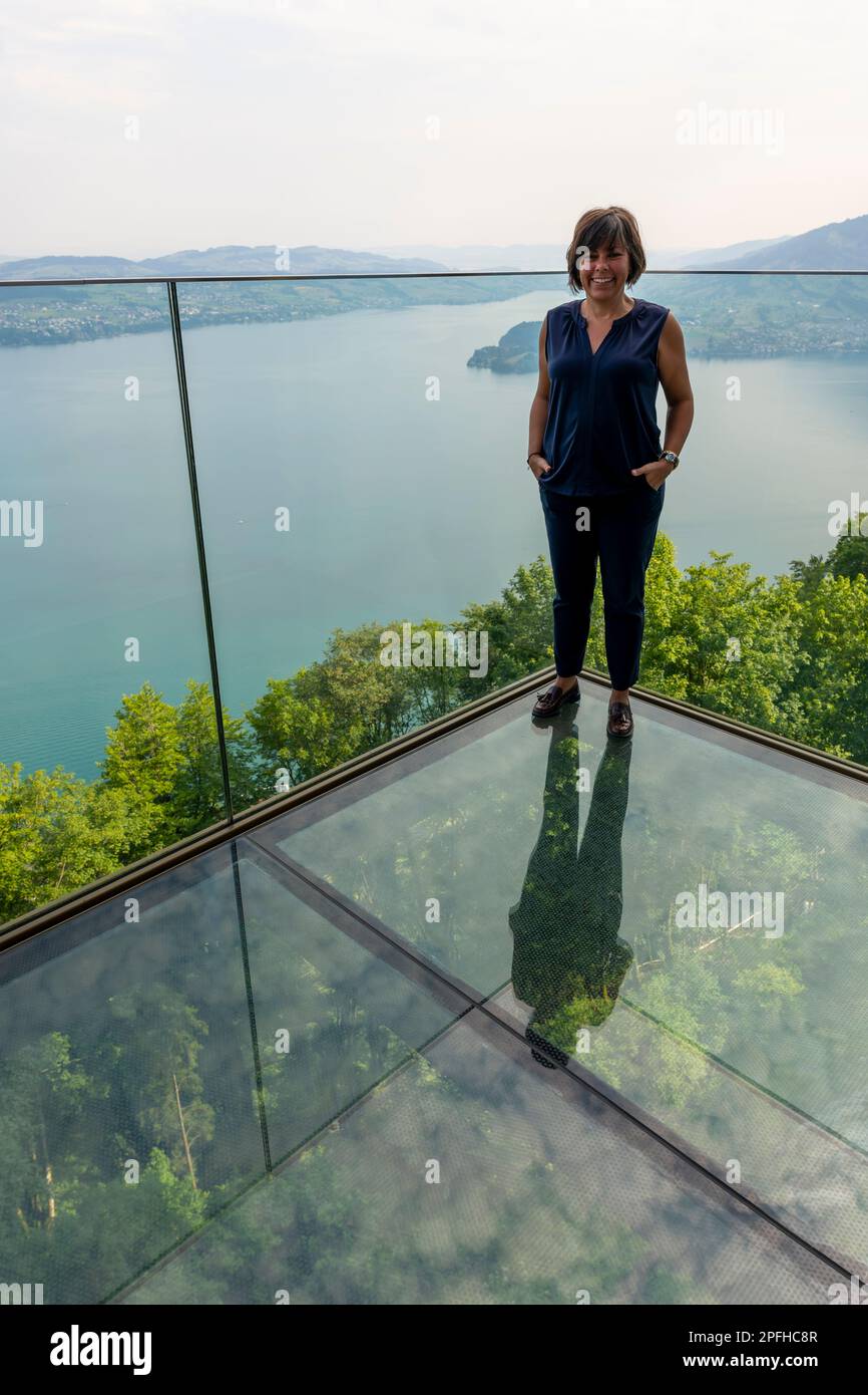 Woman Standing on a Glass Balcony with Mountain and Lake View in ...