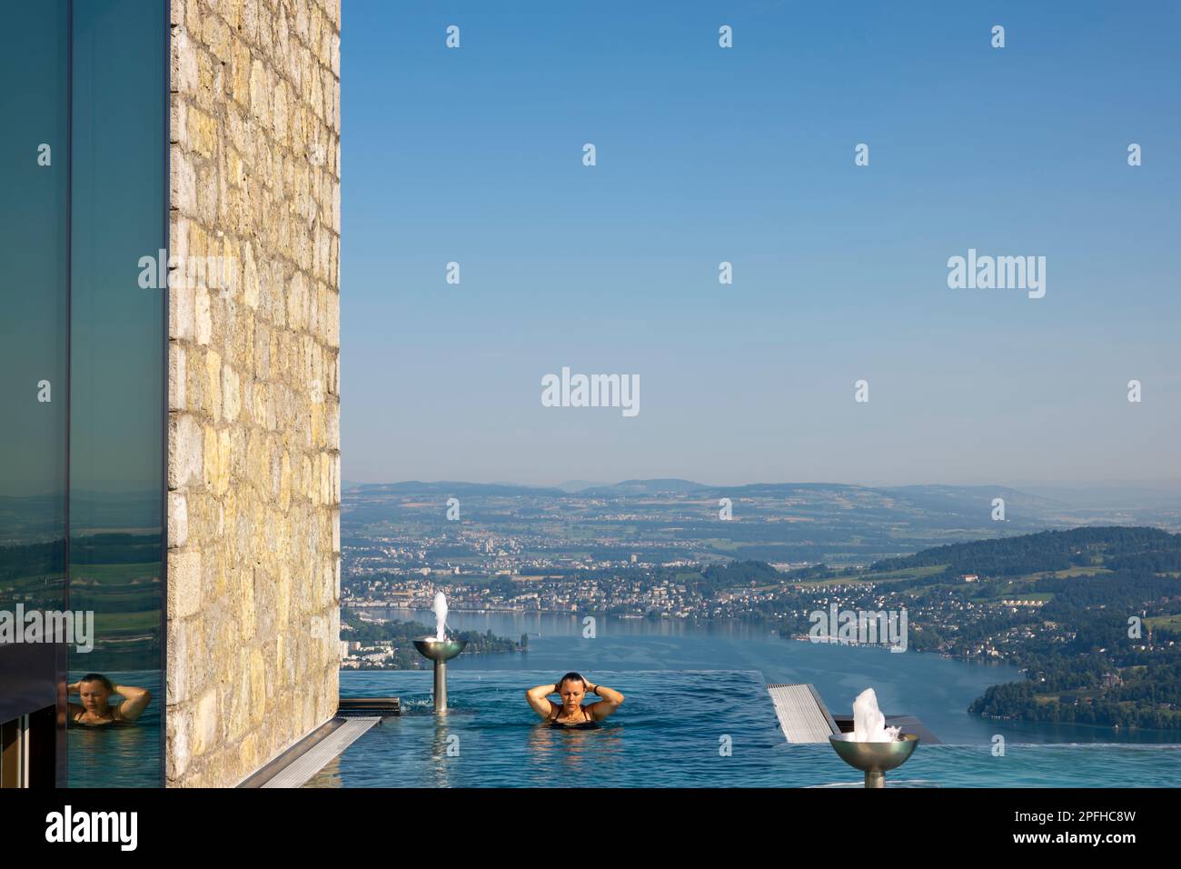 Woman in Infinity Swimming pool and Enjoy the View over Mountain and ...