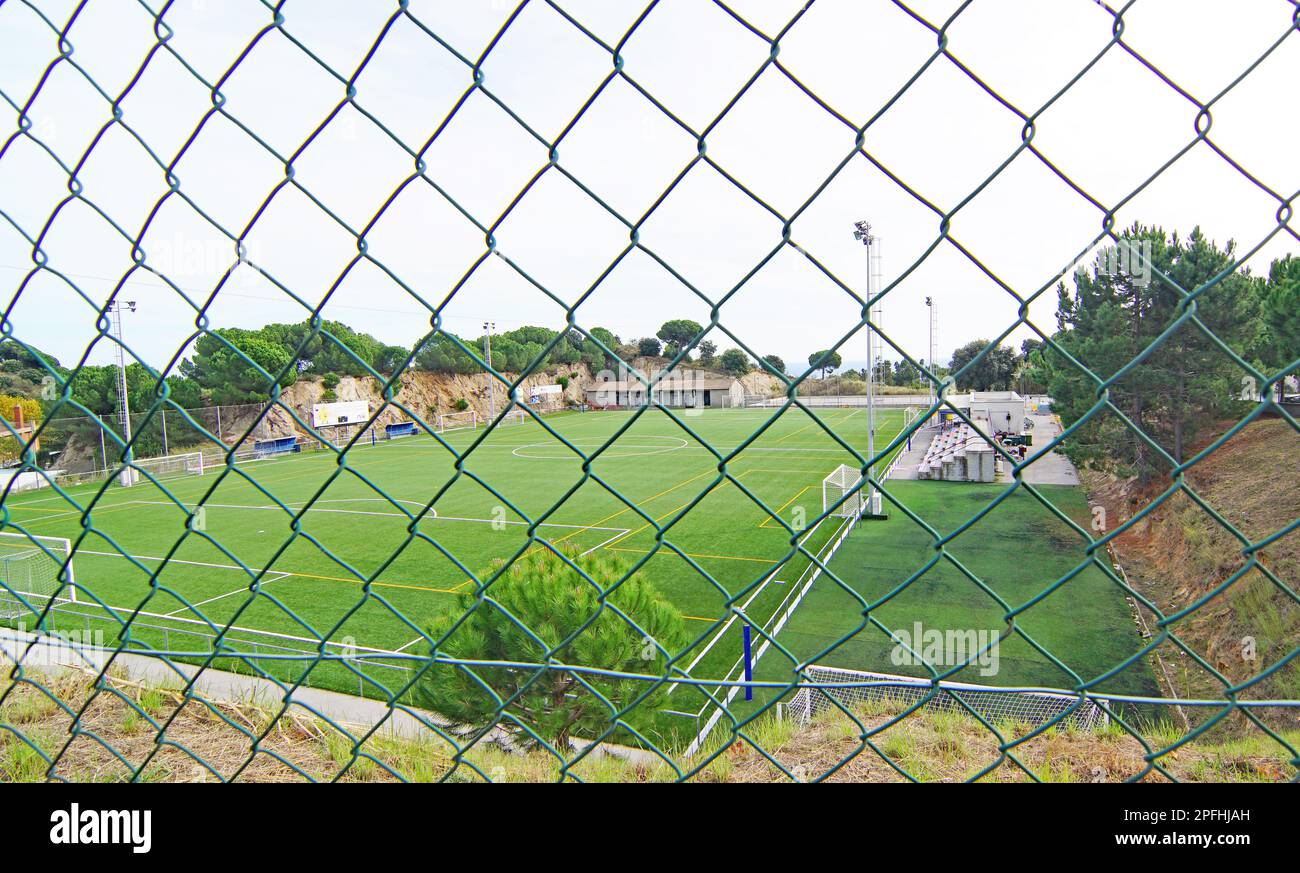 View of the Tiana soccer field through the wire fence, Tiana, Barcelona ...