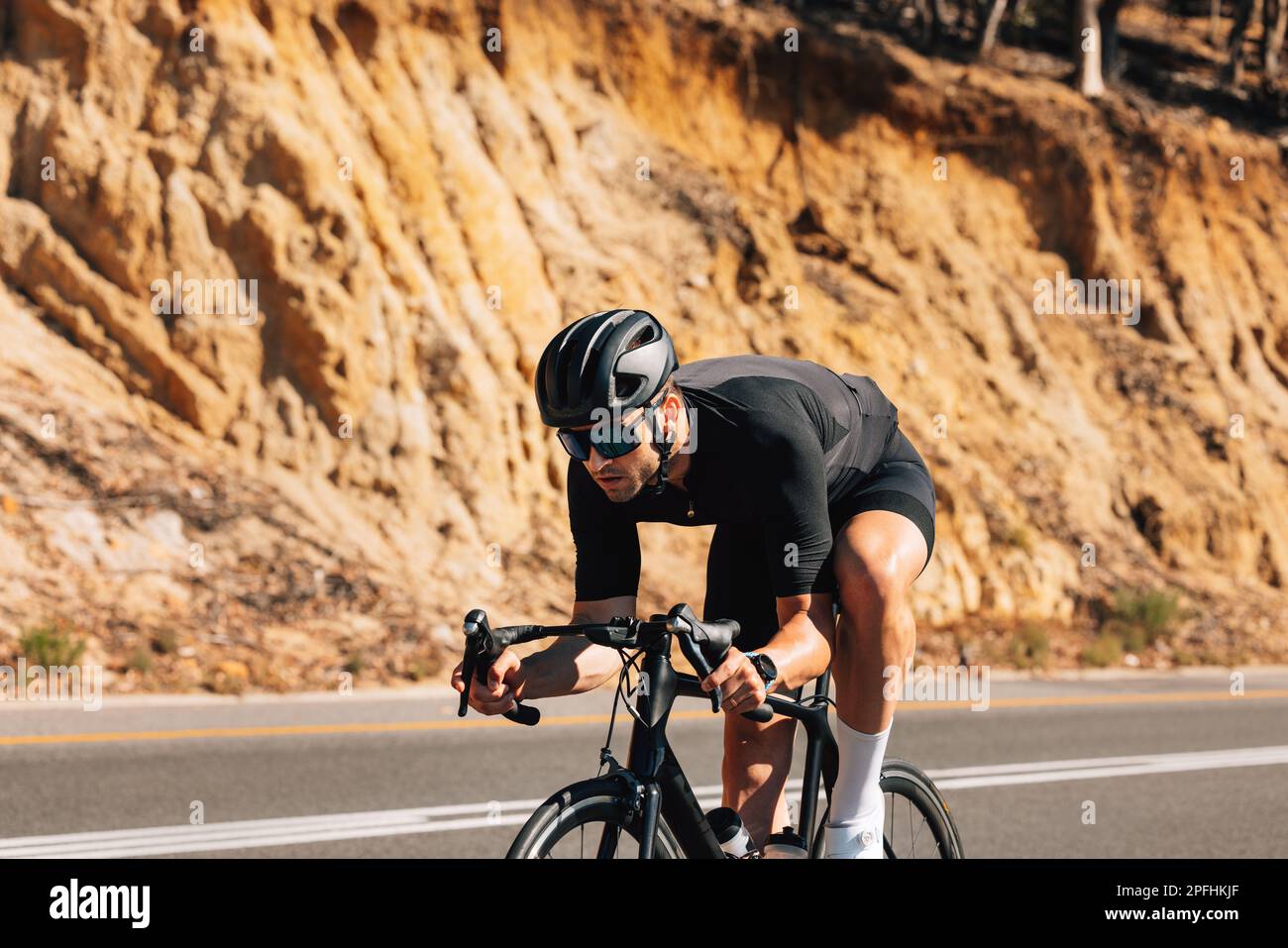 Tough cyclist on his road bike. Professional cyclist in black sport ...
