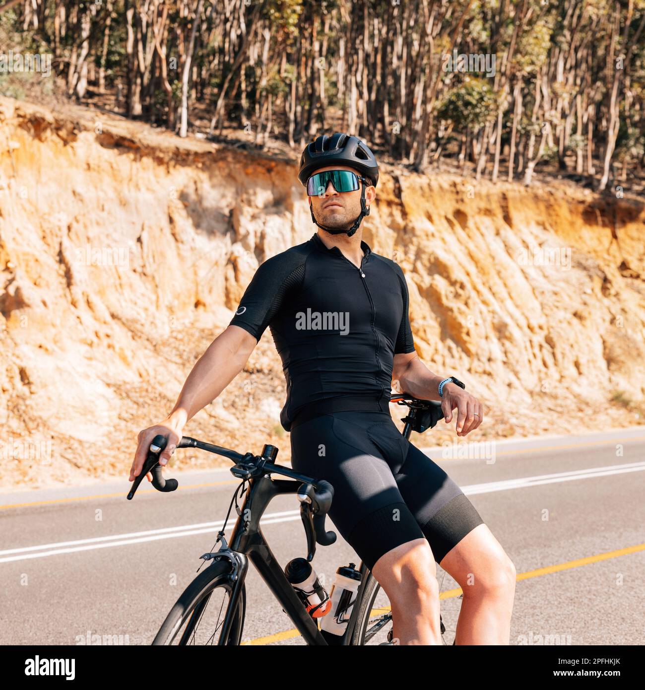 Male cyclist relaxing after an intense ride. Profesional rider resting ...